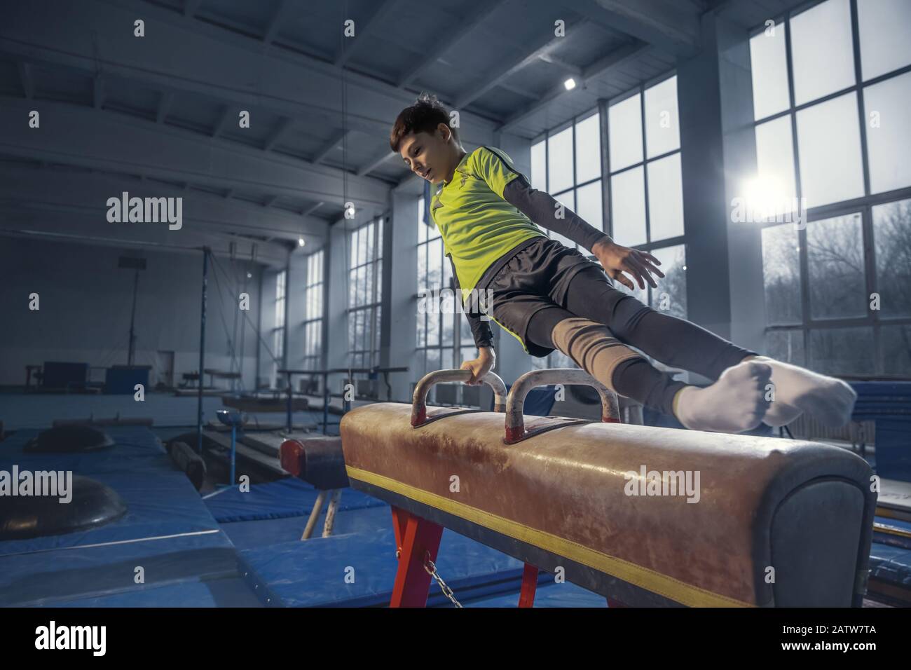 Control. Little male gymnast training in gym, flexible and active ...