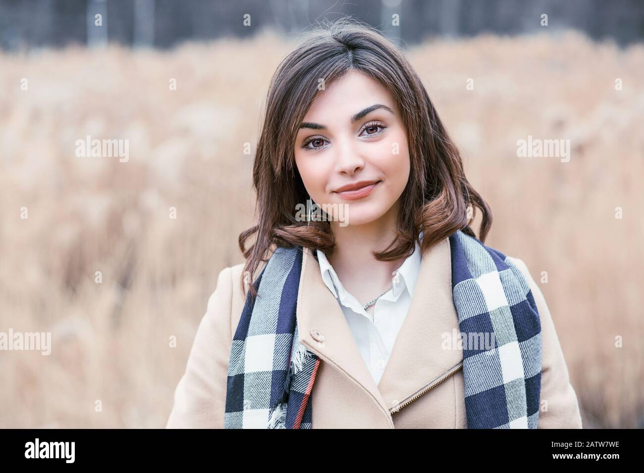Happy and cheerful. Portrait of a woman smile no teeth outdoors autumn ...