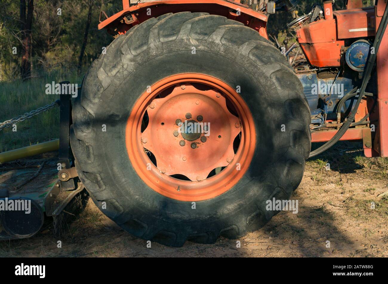 Close up of bulldozer wheel with red metal parts and black tire ...