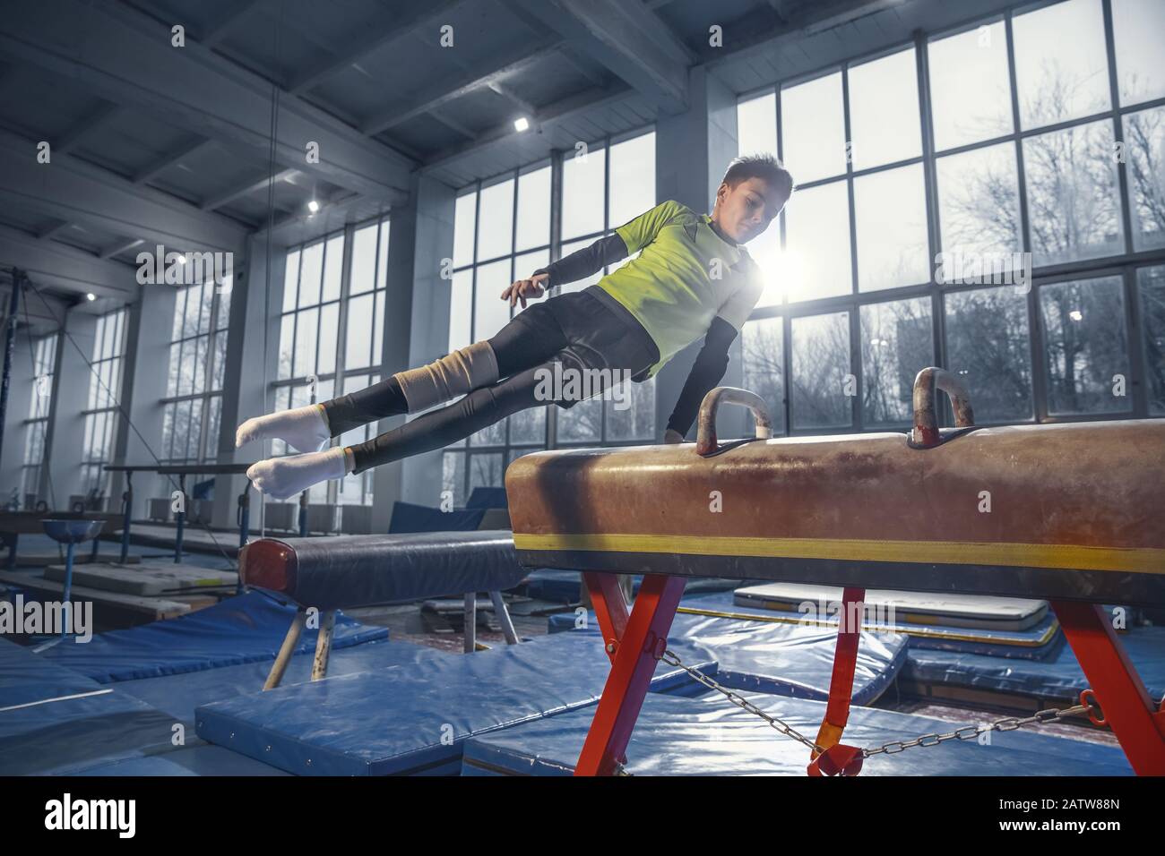 Prepared. Little male gymnast training in gym, flexible and active ...