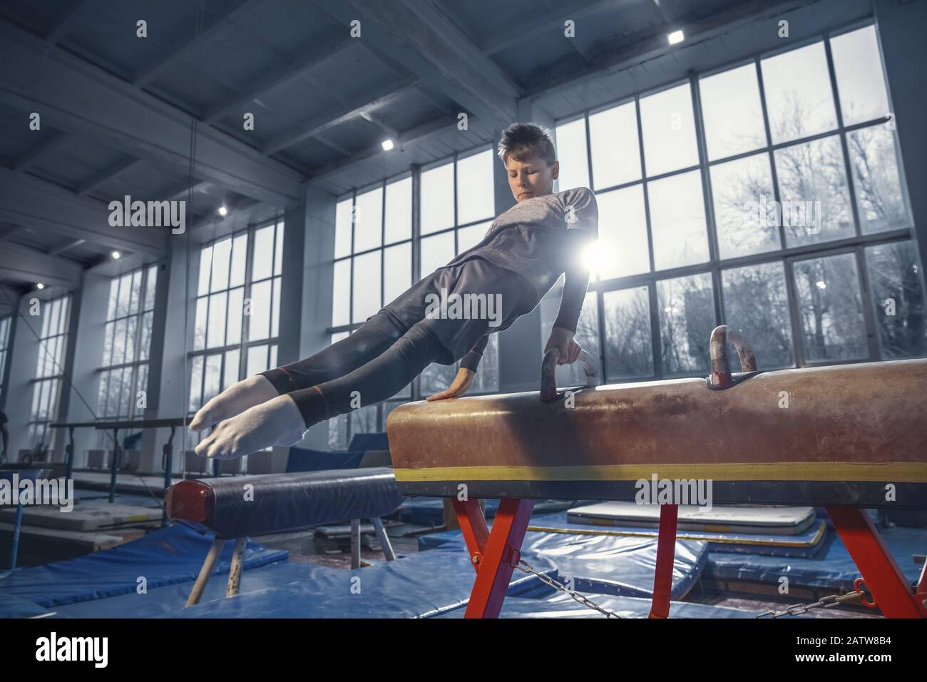 Prepared. Little male gymnast training in gym, flexible and active ...