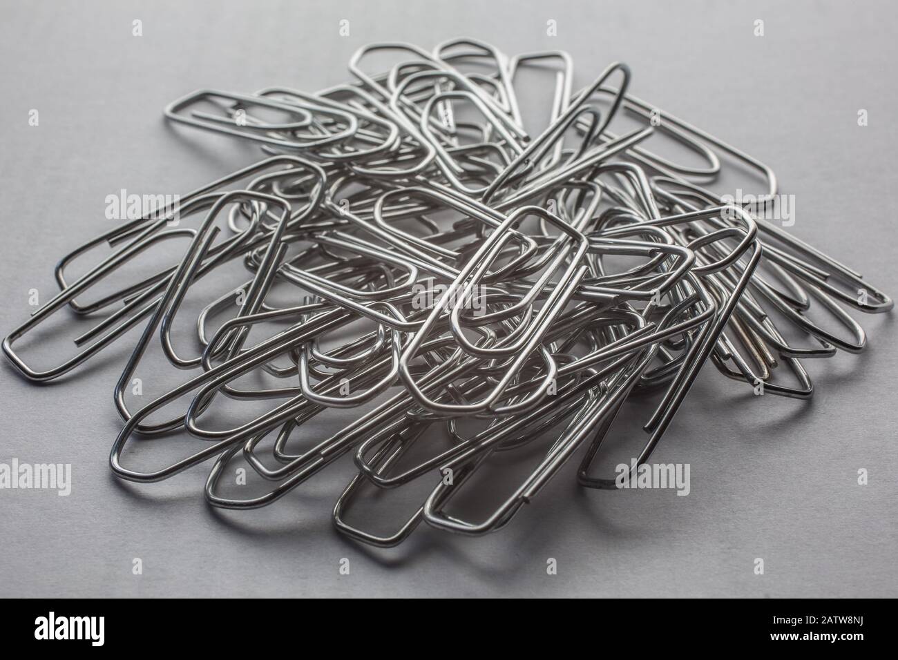 metallic silvery paper clips on a pile Stock Photo - Alamy