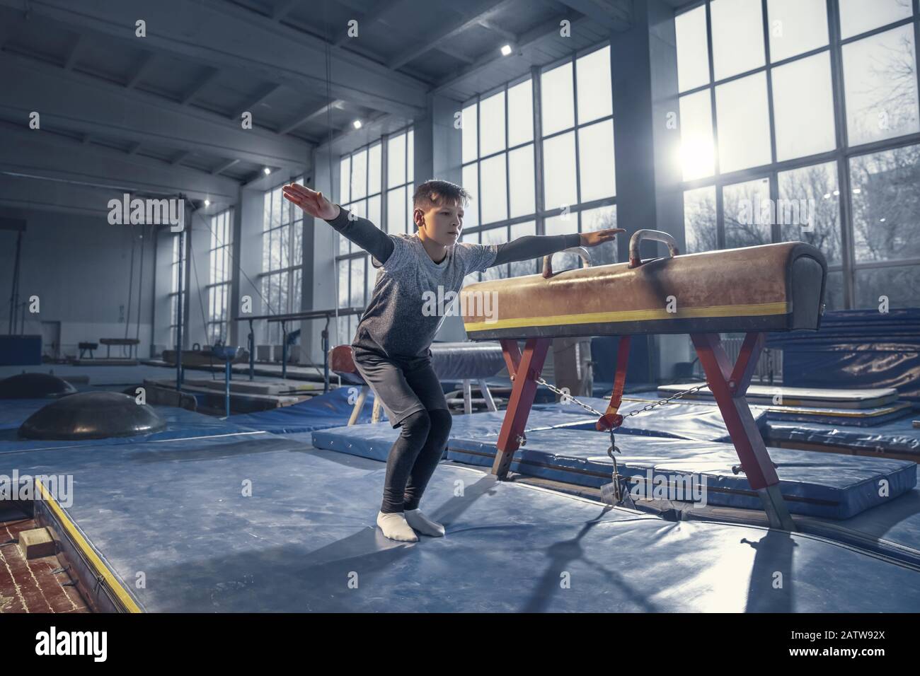 New day. Little male gymnast training in gym, flexible and active ...