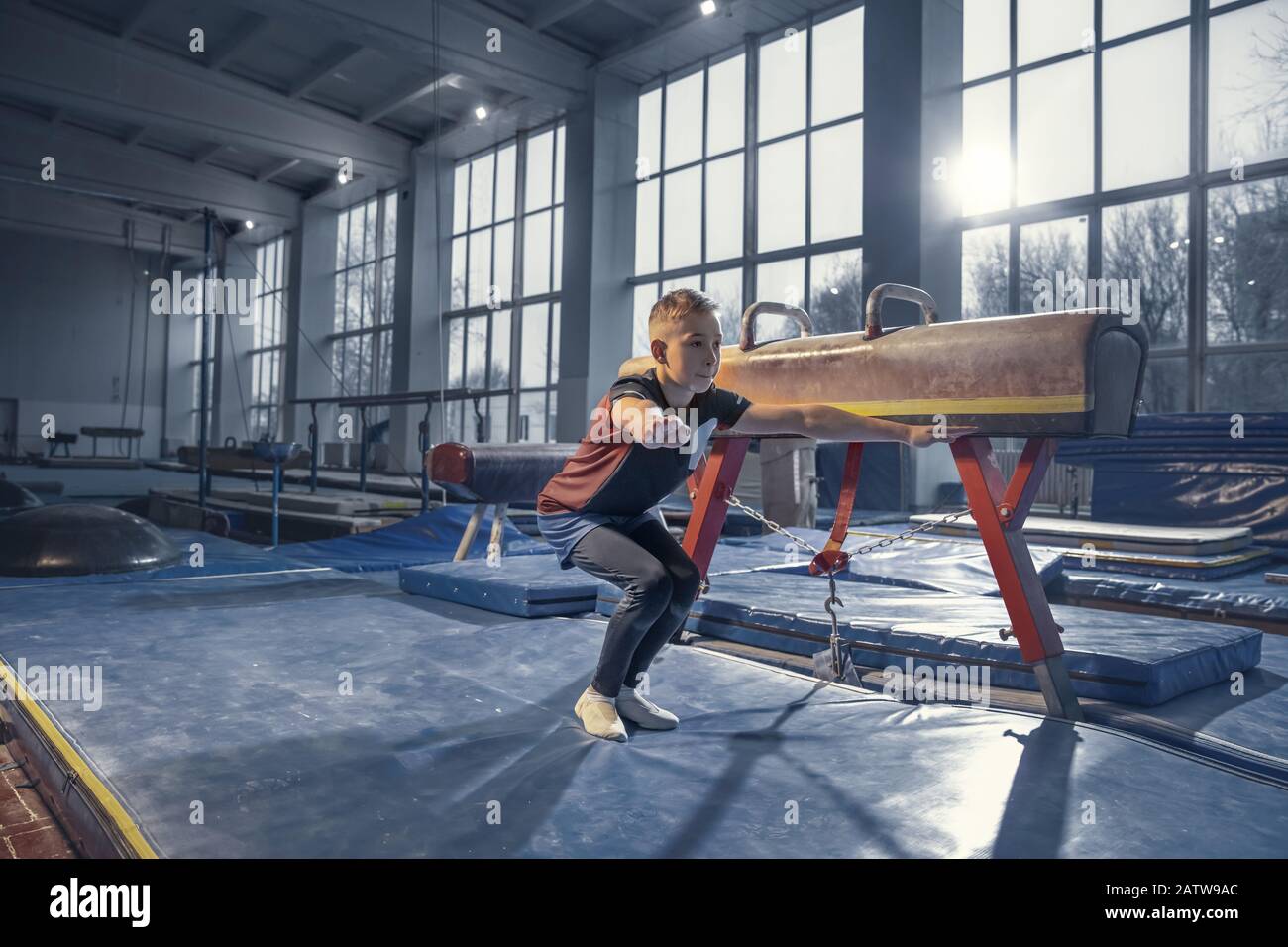 Champion. Little male gymnast training in gym, flexible and active ...