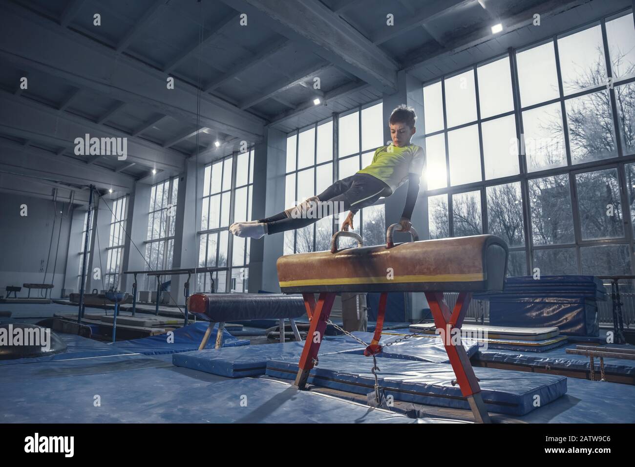 Champion. Little male gymnast training in gym, flexible and active ...
