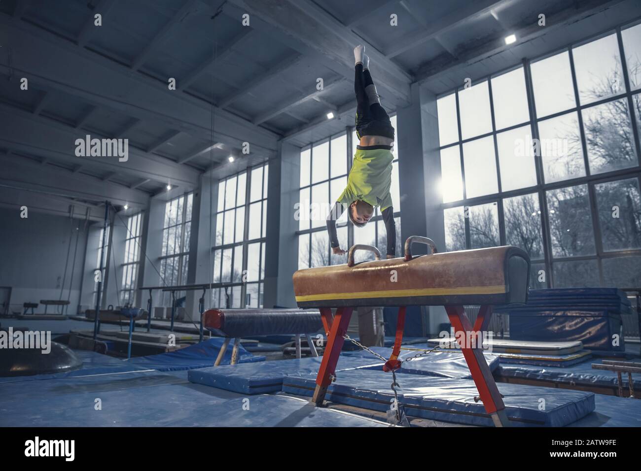 Champion. Little male gymnast training in gym, flexible and active ...