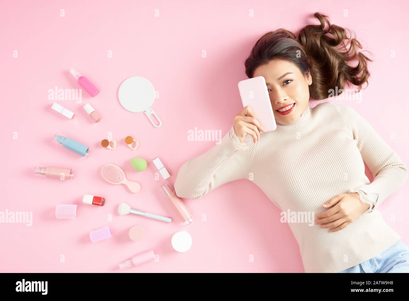 Young Asian beautiful woman show smart phone with her cosmetic makeup ...