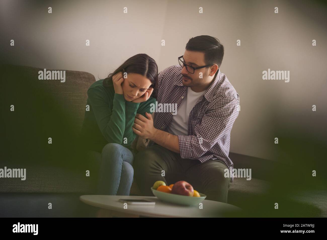 Woman is sad, her man is consoling her Stock Photo - Alamy