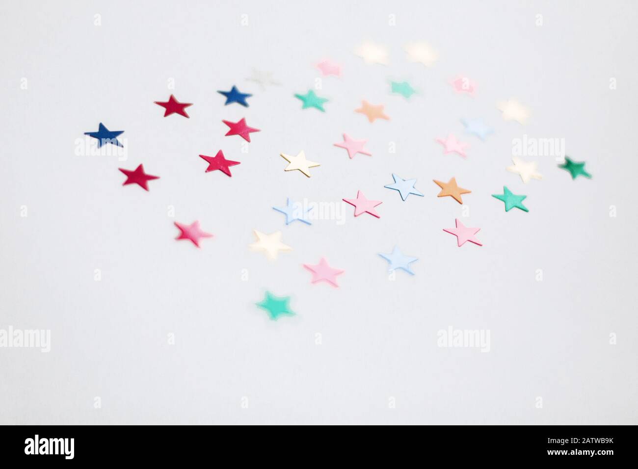 Colorful stars confetti or glitter on white background. Party backdrop ...