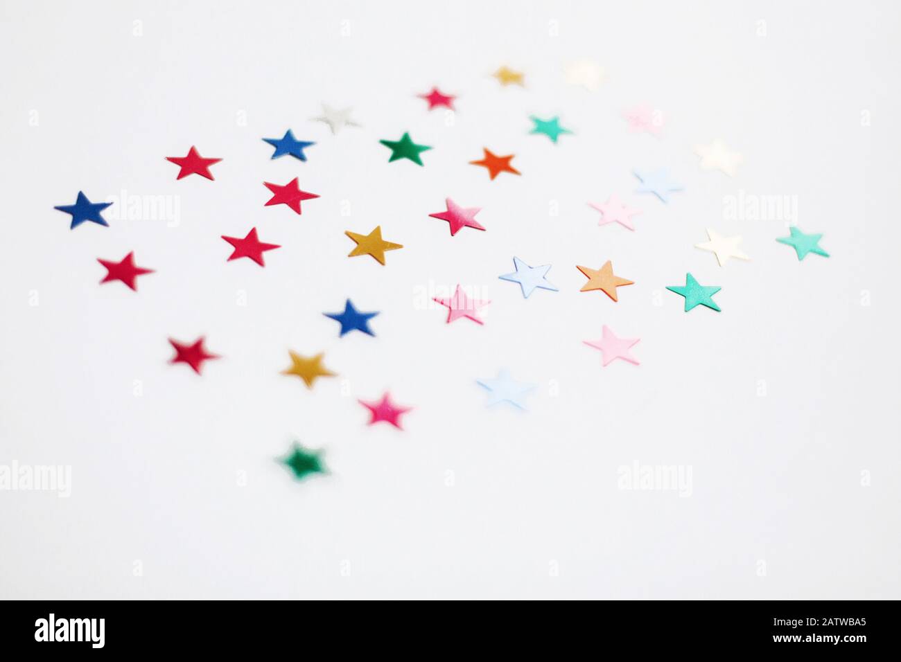 Colorful stars confetti or glitter on white background. Party backdrop ...