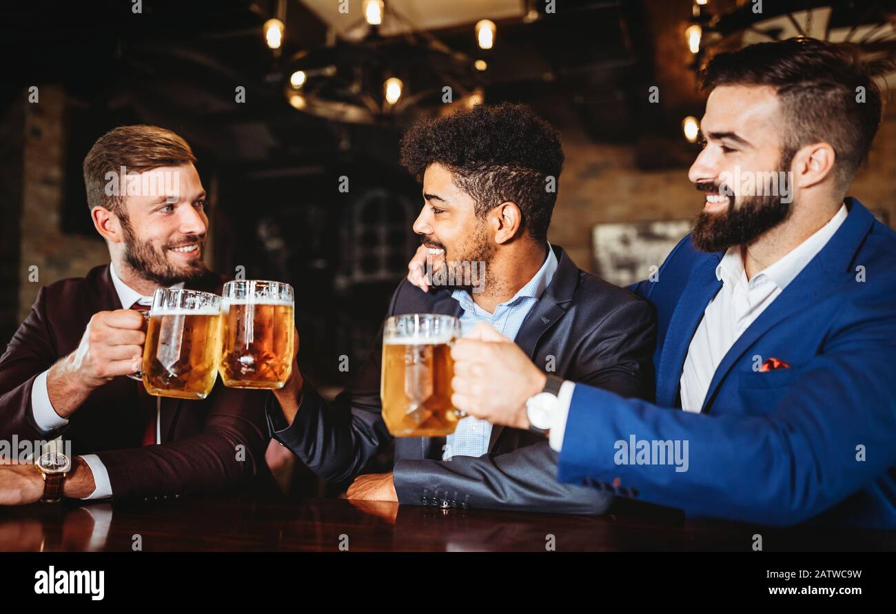 Team of colleagues socializing at the bar and drinking beers Stock ...