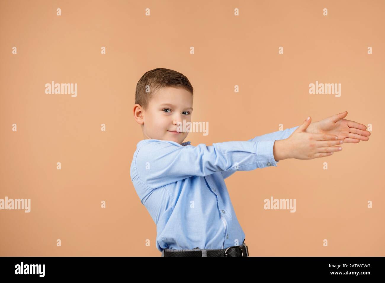 Cute smiling little child boy pointing to the side and looking at the ...