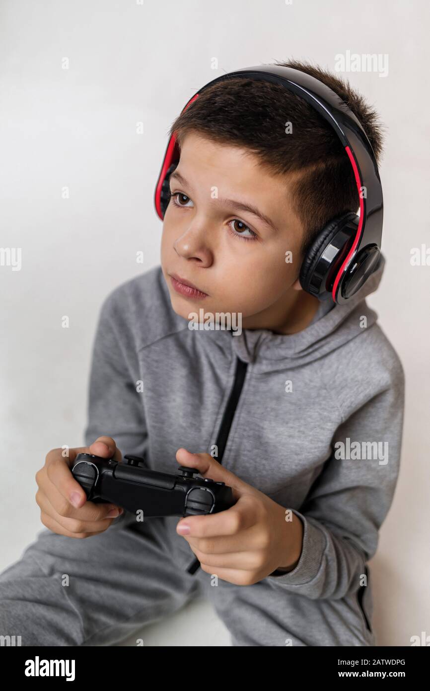 child boy playing video games over gray background. young gamer playing ...