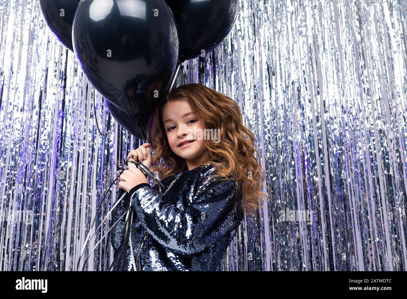Attractive young caucasian girl holding black helium balloons on a ...
