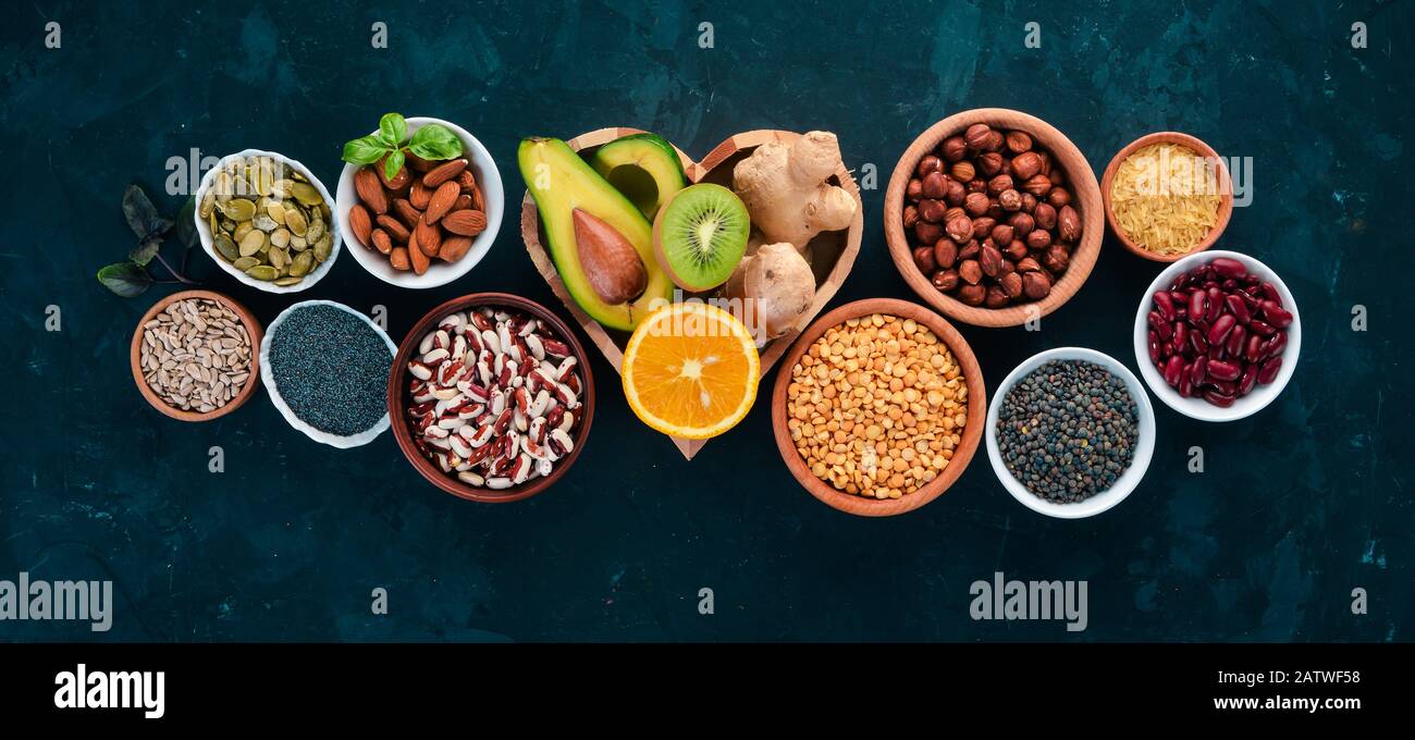 Superfoods Healthy food. Nuts, berries, fruits, and legumes. On a black ...