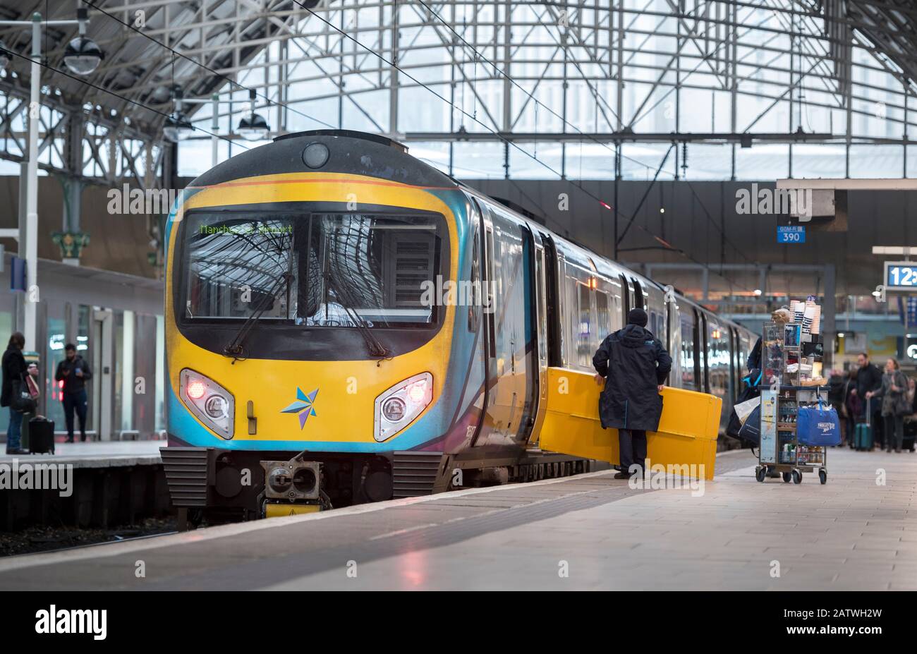 Member of staff taking a ramp to a Class 185 passenger train in ...