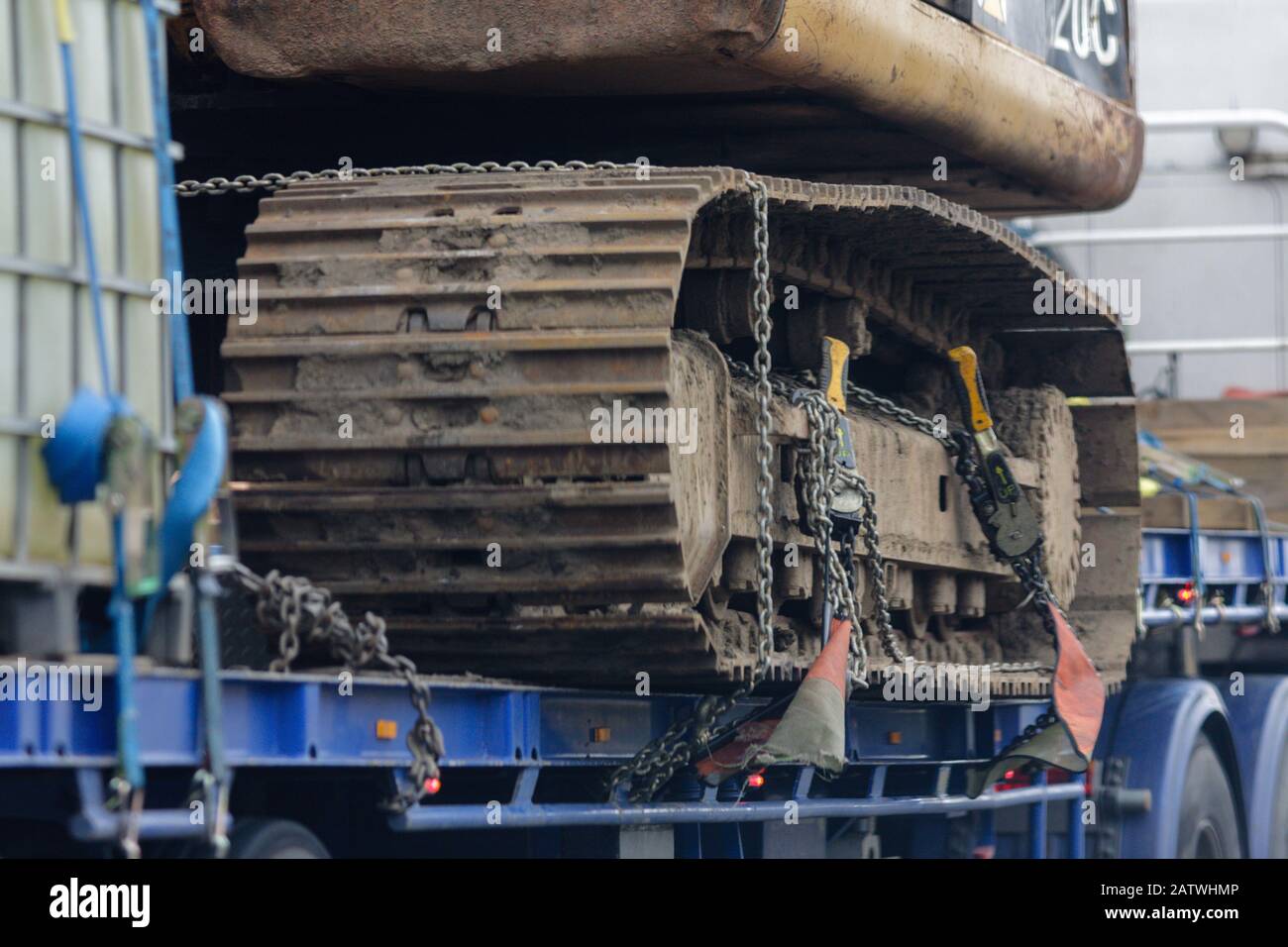 heavy duty excavator track chained on a truck on the highway in ...