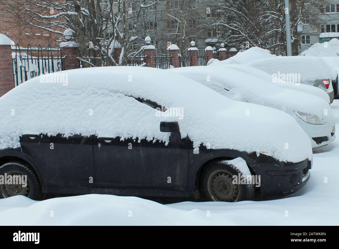 Car on a city street in winter covered with snow Stock Photo - Alamy