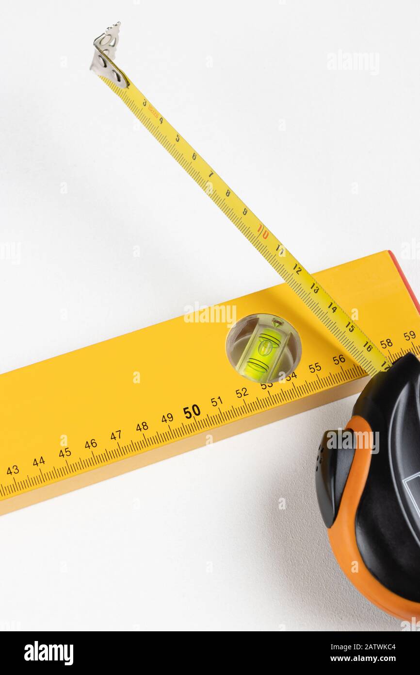 Yellow tape measure and spirit level on clear white background. Place ...