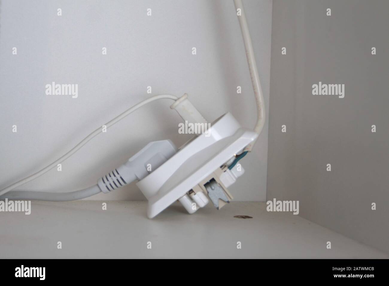 Two electrical plugs are plugged into a broken outlet Stock Photo - Alamy