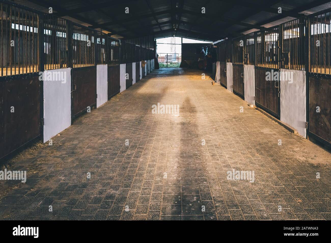 Old box for animals in an empty stable with bars and wooden doors for ...