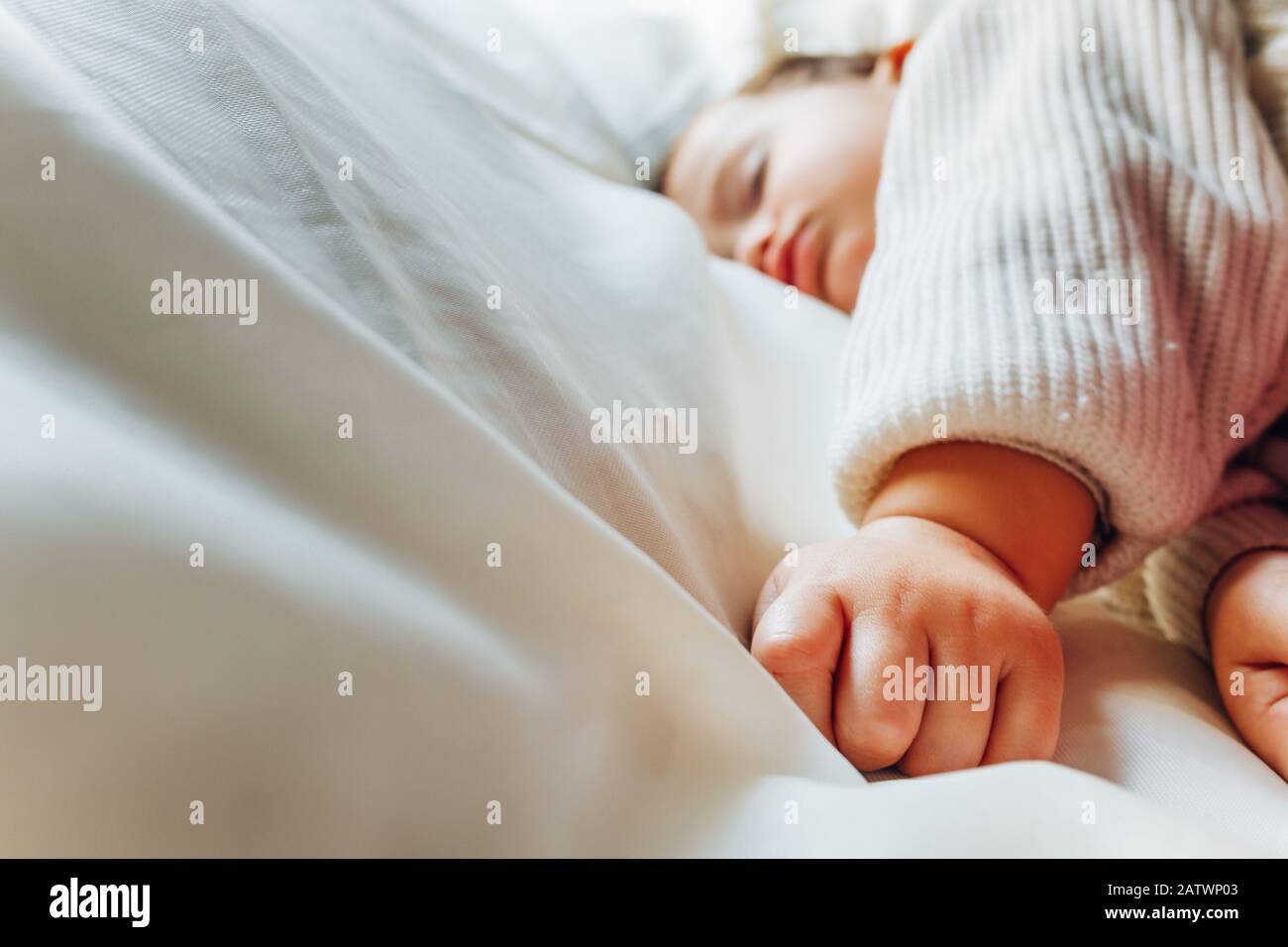 Close-up of a baby's hand sleeping during a nap, isolated on white ...