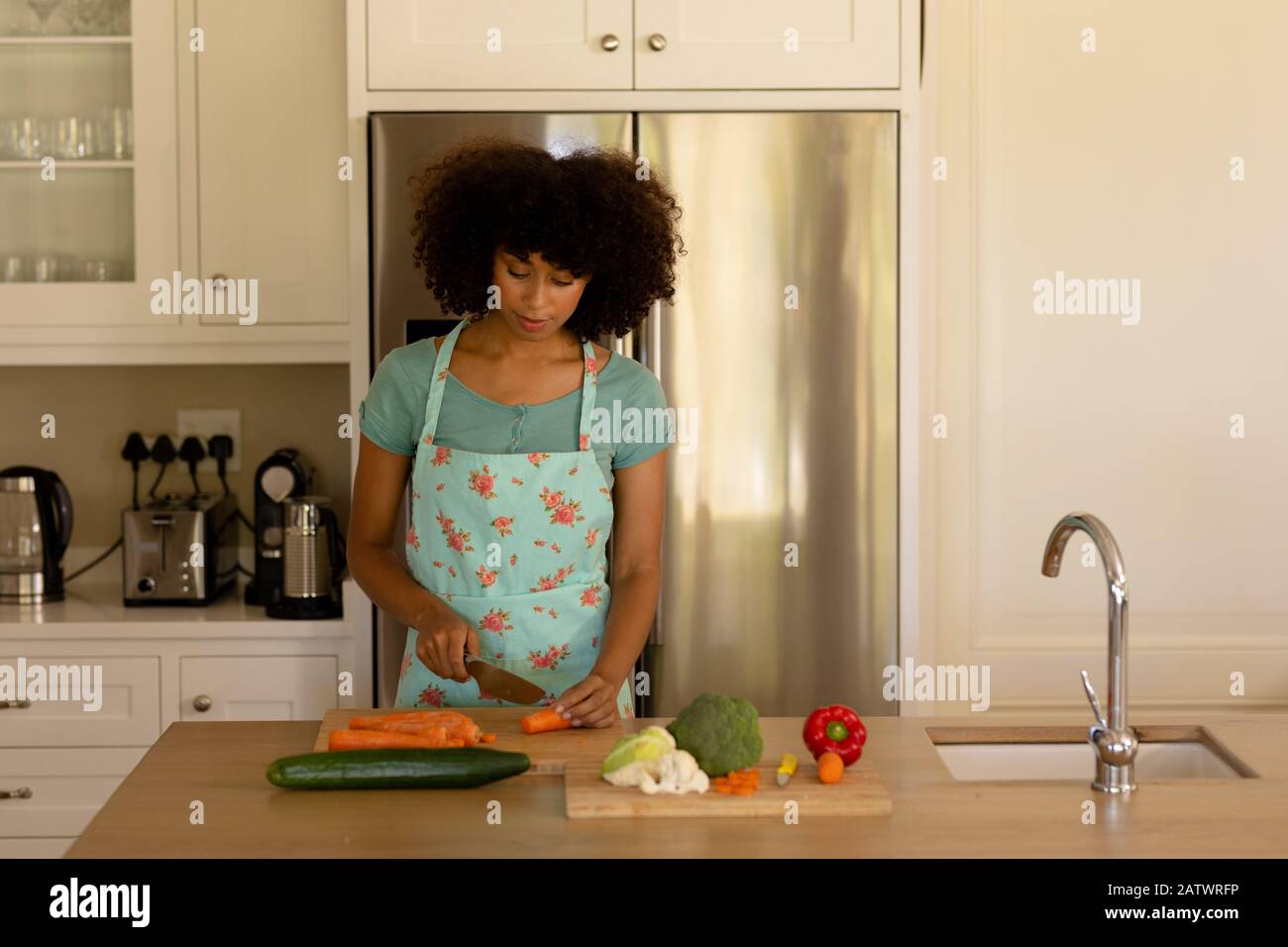 Young woman cooking and wearing apron in the kitchen Stock Photo - Alamy