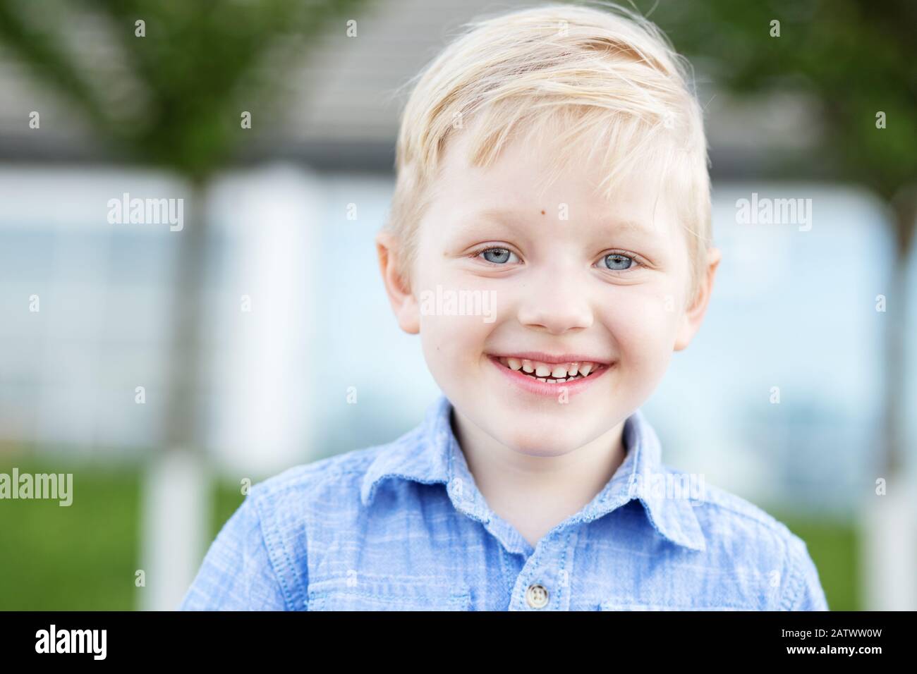 The blue-eyed child is smiling. The little boy is blond. The concept of ...