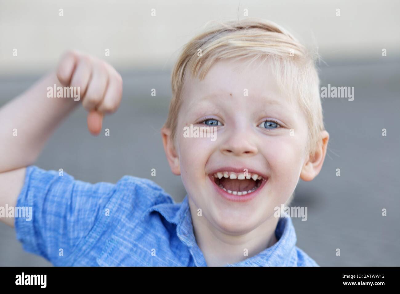 A small strong child shows his muscles and smiles. The concept of ...