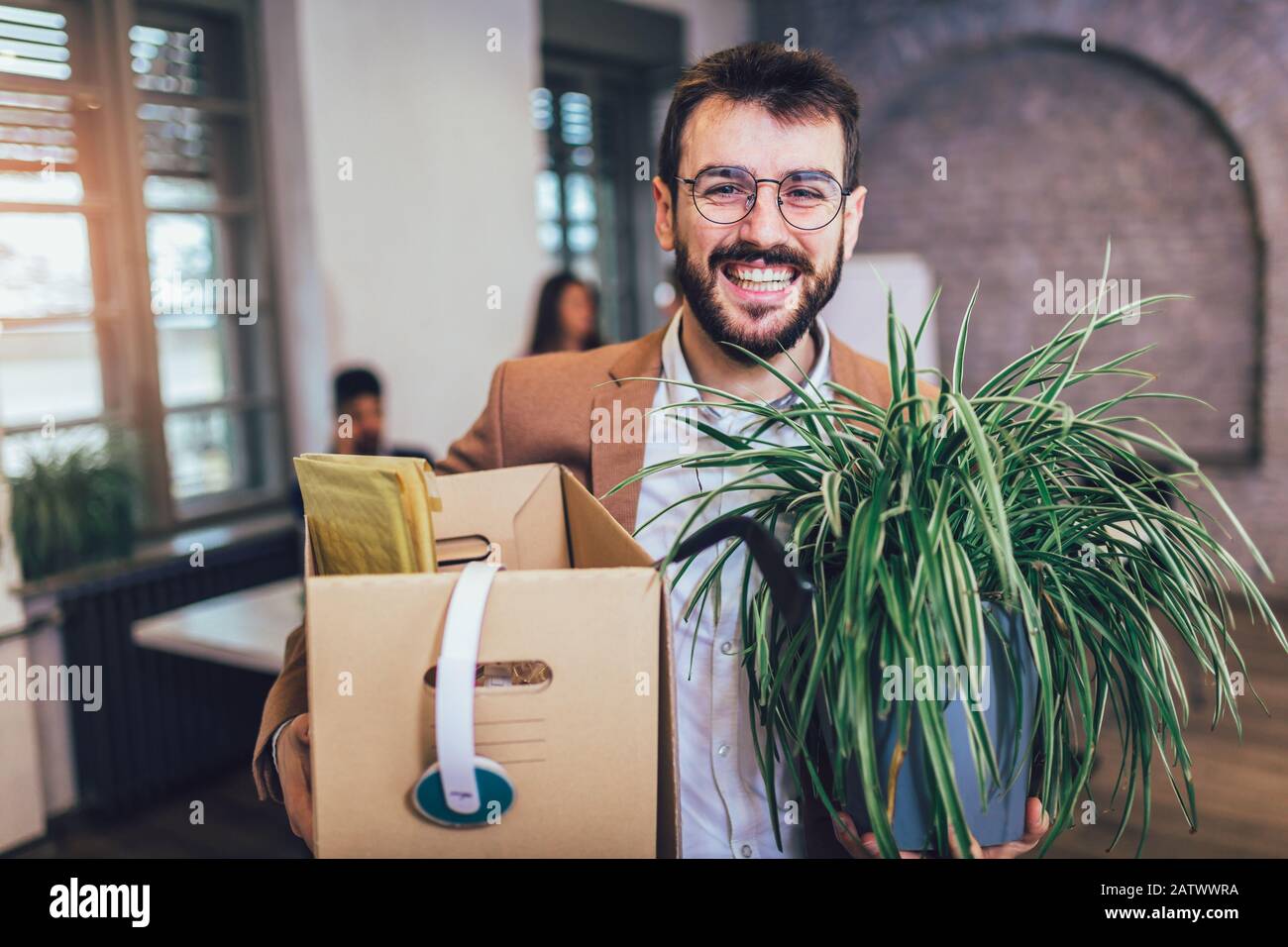 Man having first working day getting in modern office, holding with his ...