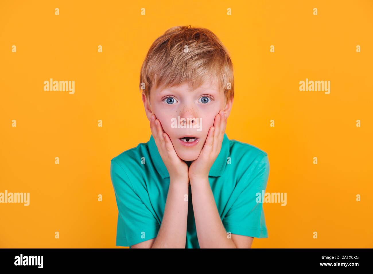 Photo of shocked little boy child with freckles over yellow background ...