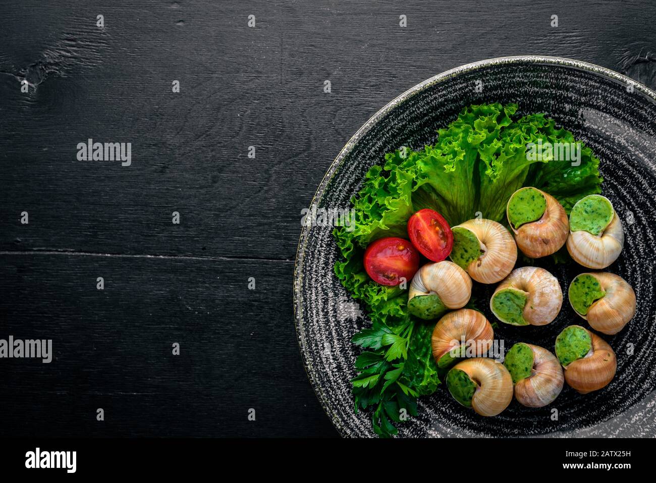 French and Italian cuisine. Baked snails. On a wooden background. Top ...
