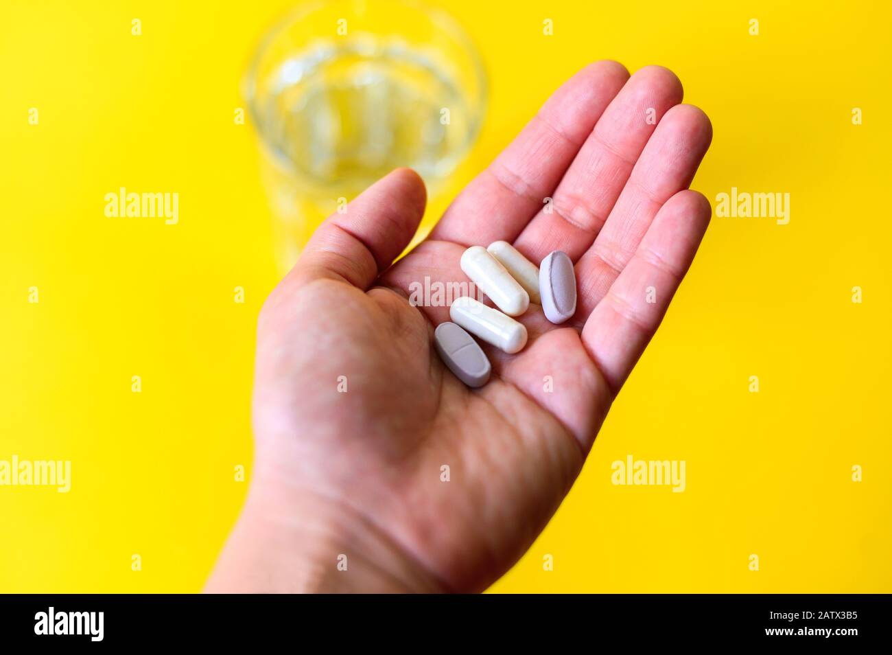 capsule in hand yellow background Stock Photo - Alamy