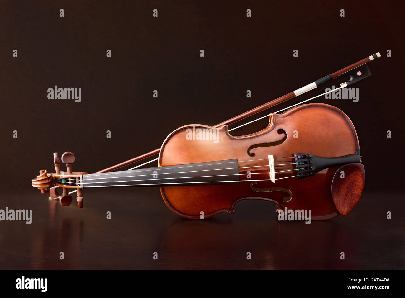 Violin reflected on wooden table and brown gradient background ...