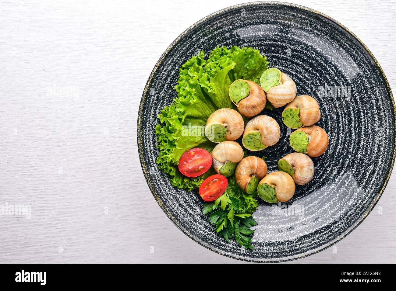 French and Italian cuisine. Baked snails. On a wooden background. Top ...