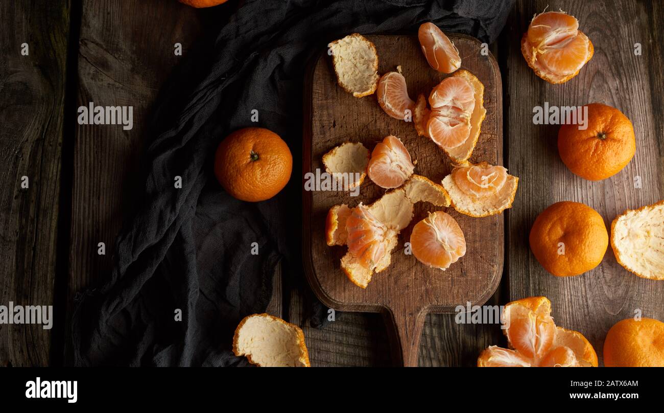 ripe round tangerines and cut in half on an old vintage cutting board ...