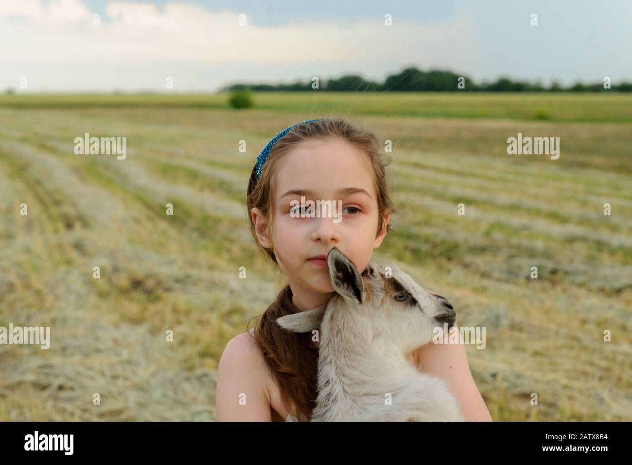 girl with baby goat on farm outdoors. Love and care. Village animals ...