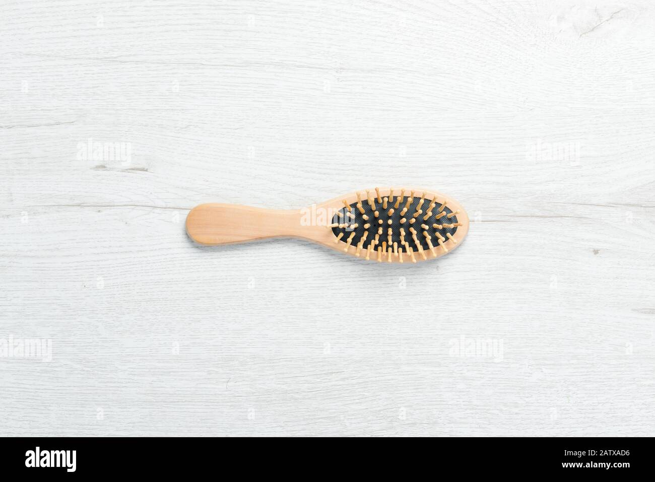 Wooden comb for hair on a white wooden background. Top view. Free space ...