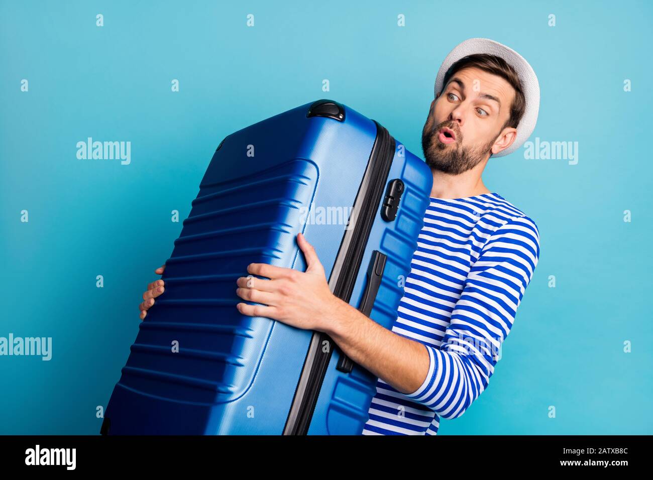 Photo of handsome guy traveler hold big suitcase plane flight weight ...