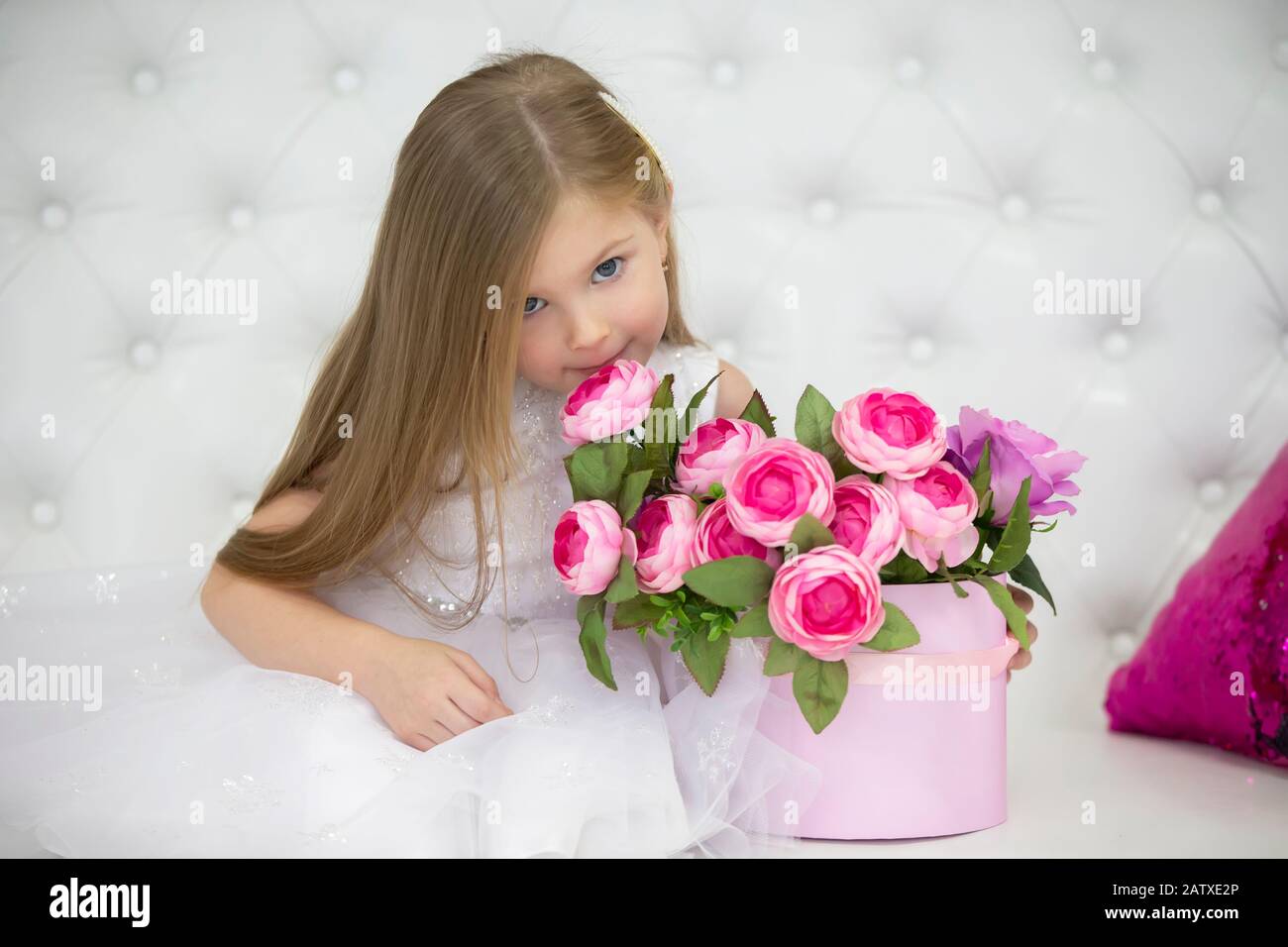 Beautiful child girl sniffing flowers Stock Photo - Alamy