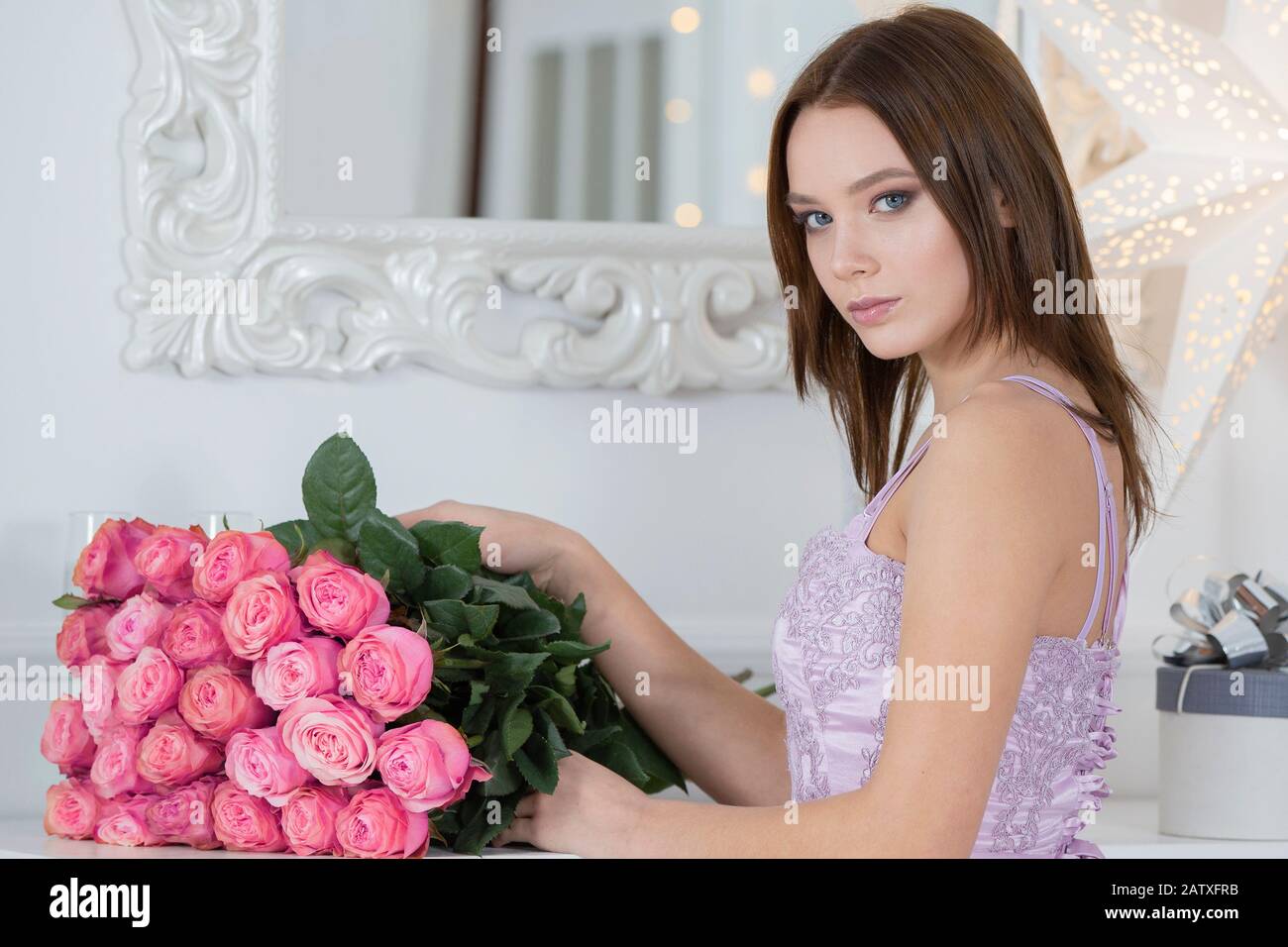 Portrait of a beautiful woman with a bouquet of roses. Girl with ...