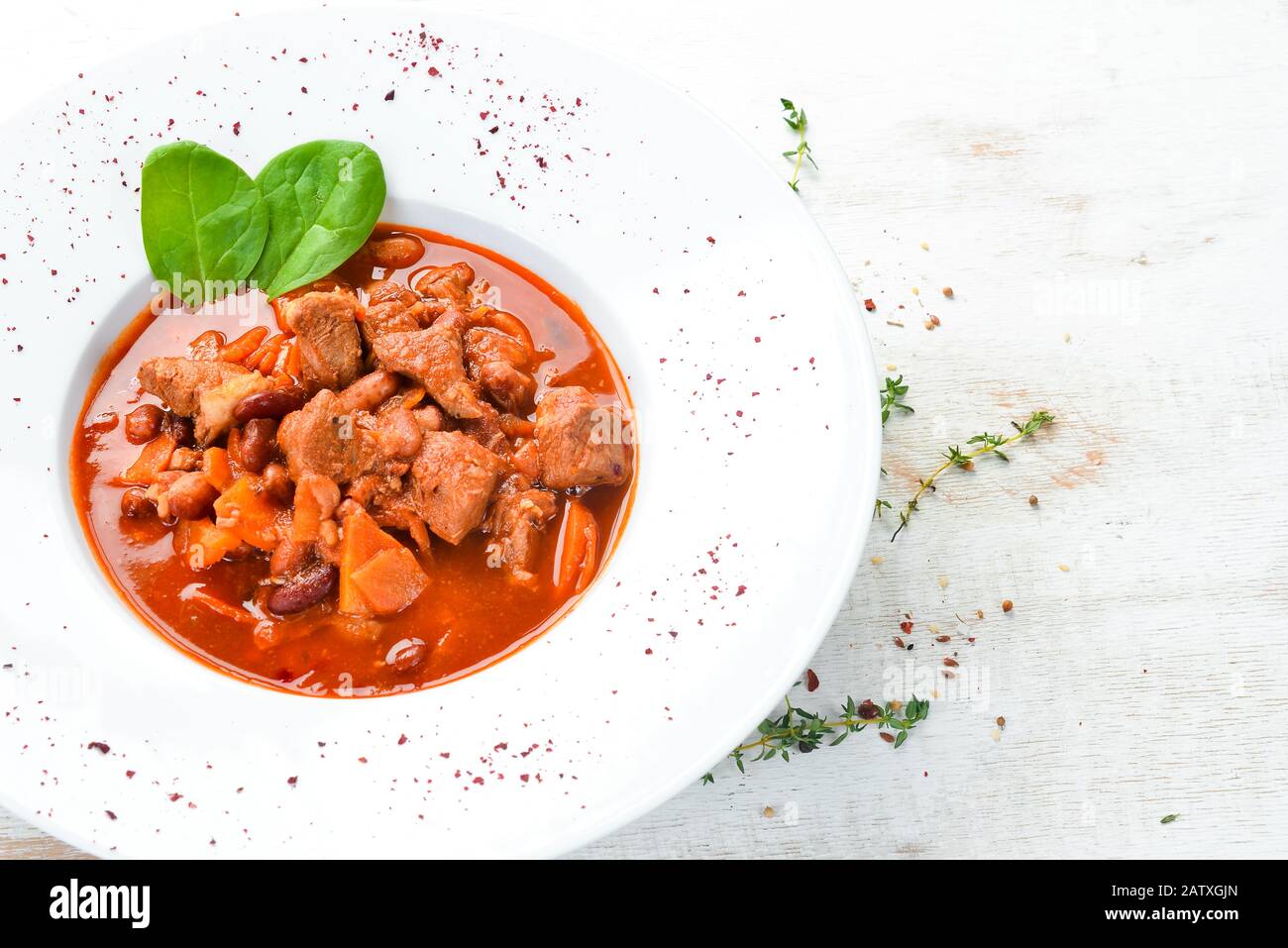 Beef stew with beans and vegetables in a tomato sauce on a plate. Top ...