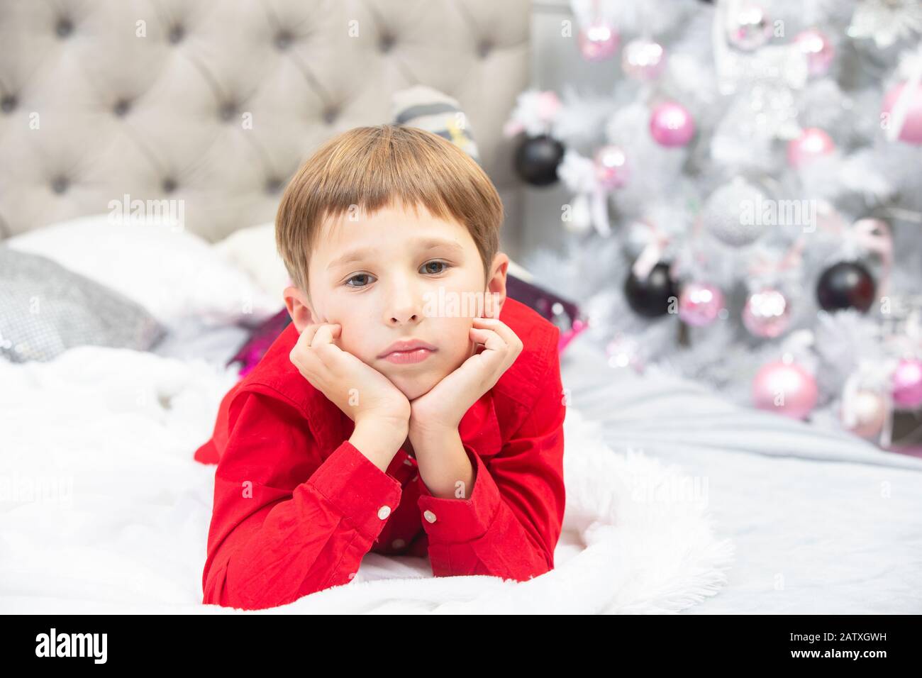Sad child in Christmas on the background of a decorated Christmas tree ...