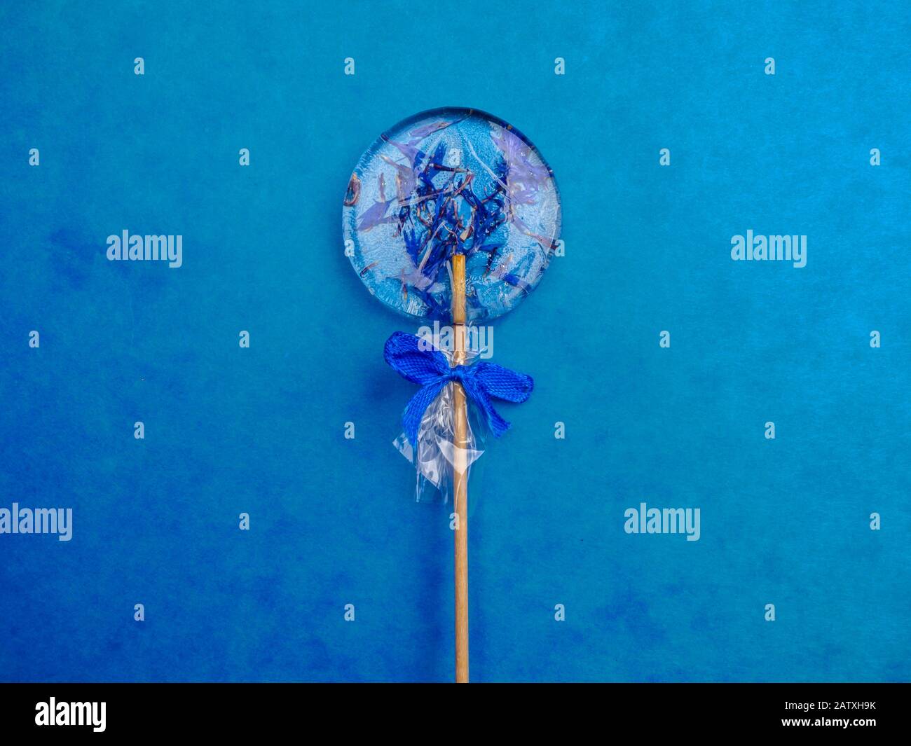 Round lollipop with blue cornflower on trendy blue classic background ...