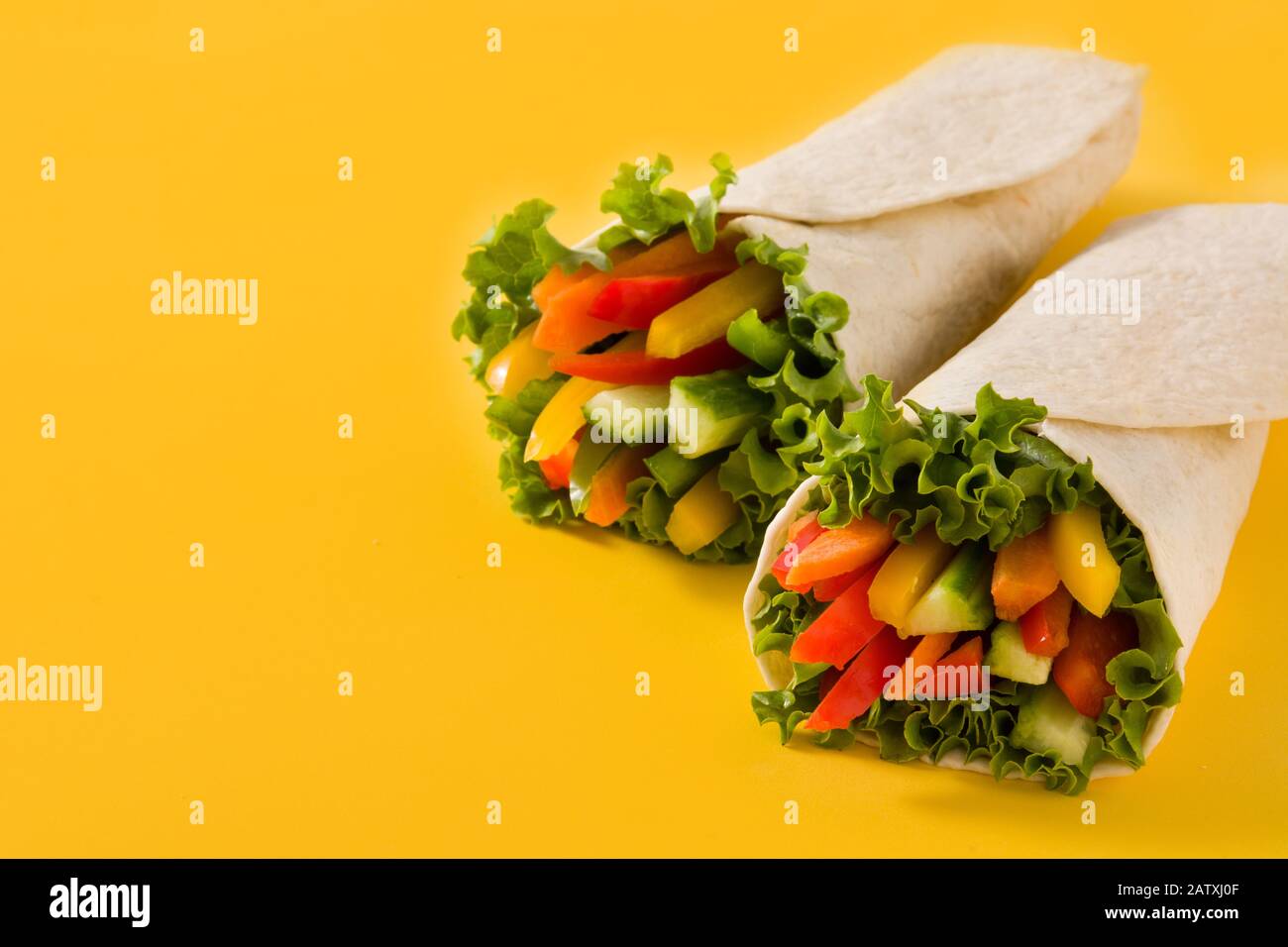Vegetable tortilla wraps on yellow background Stock Photo - Alamy