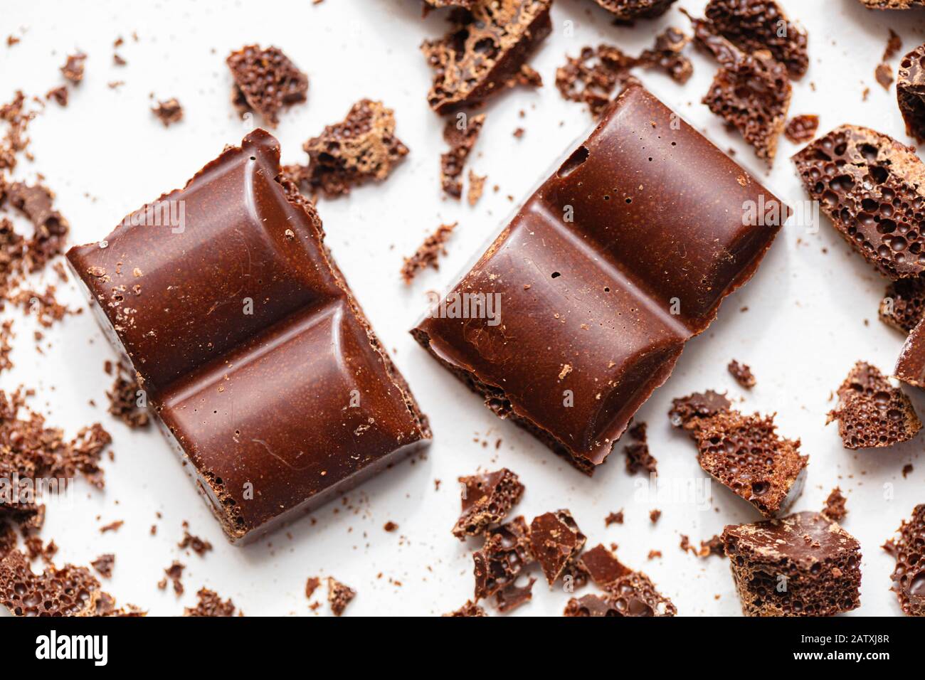 Large pieces of chocolate with slices. Crushed chocolate on a white ...