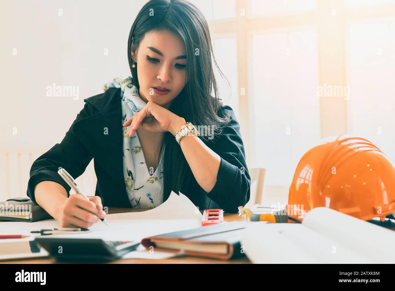 Female architect working on blueprint architects project in office ...