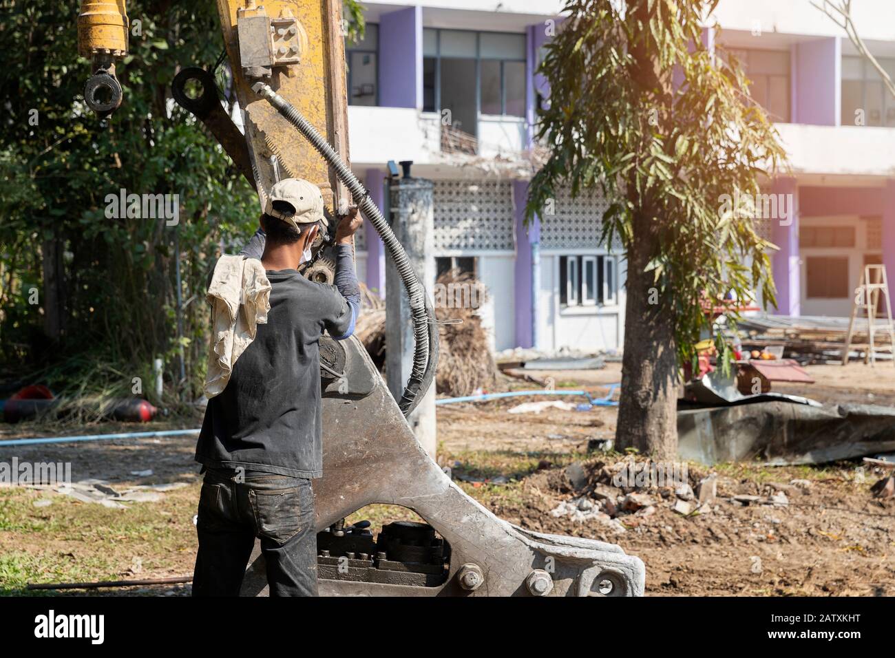 The mechanic is repairing the arm of the drilling excavator Stock Photo ...
