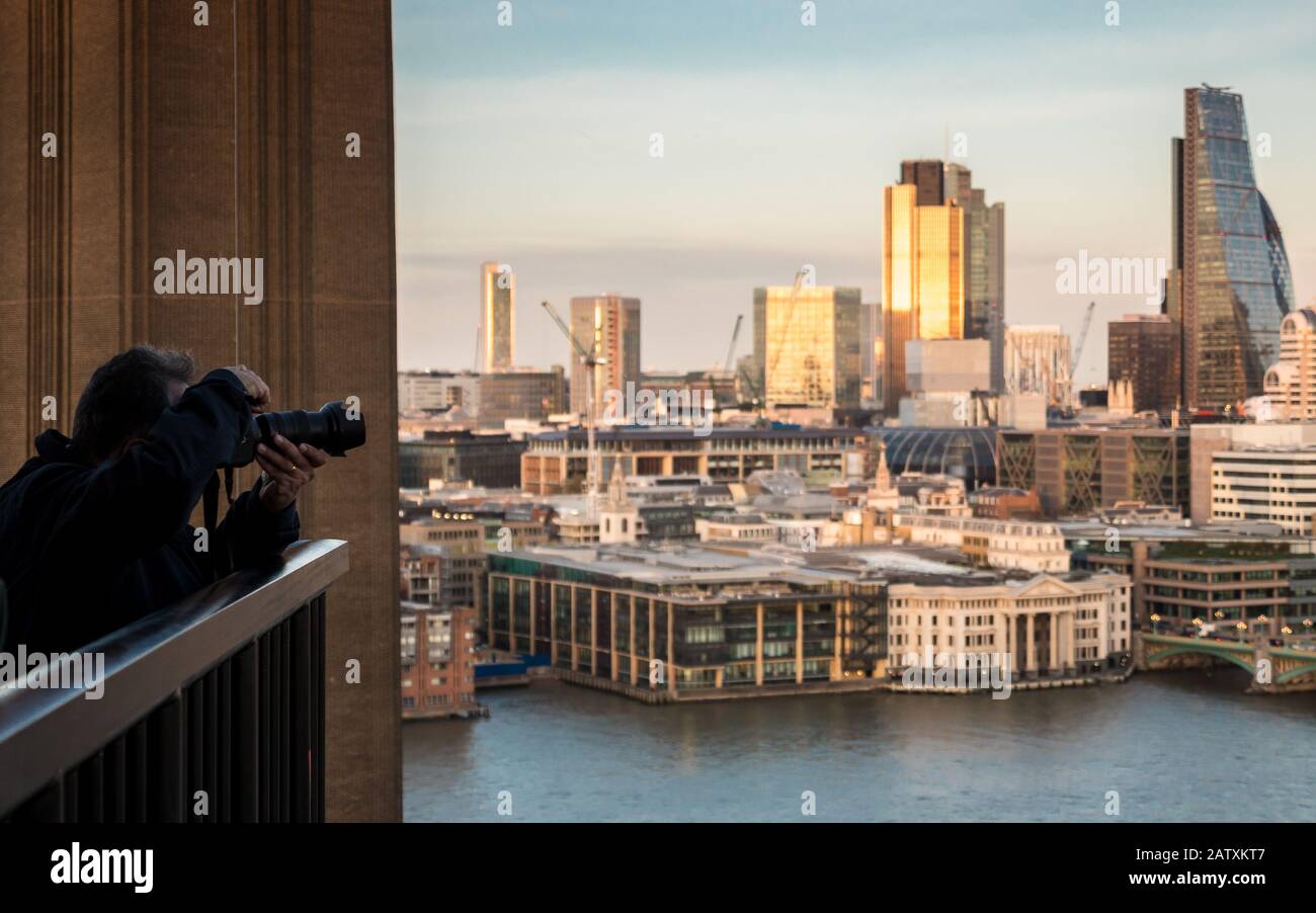 A tourist taking photos of the City of London skyline from the viewing ...