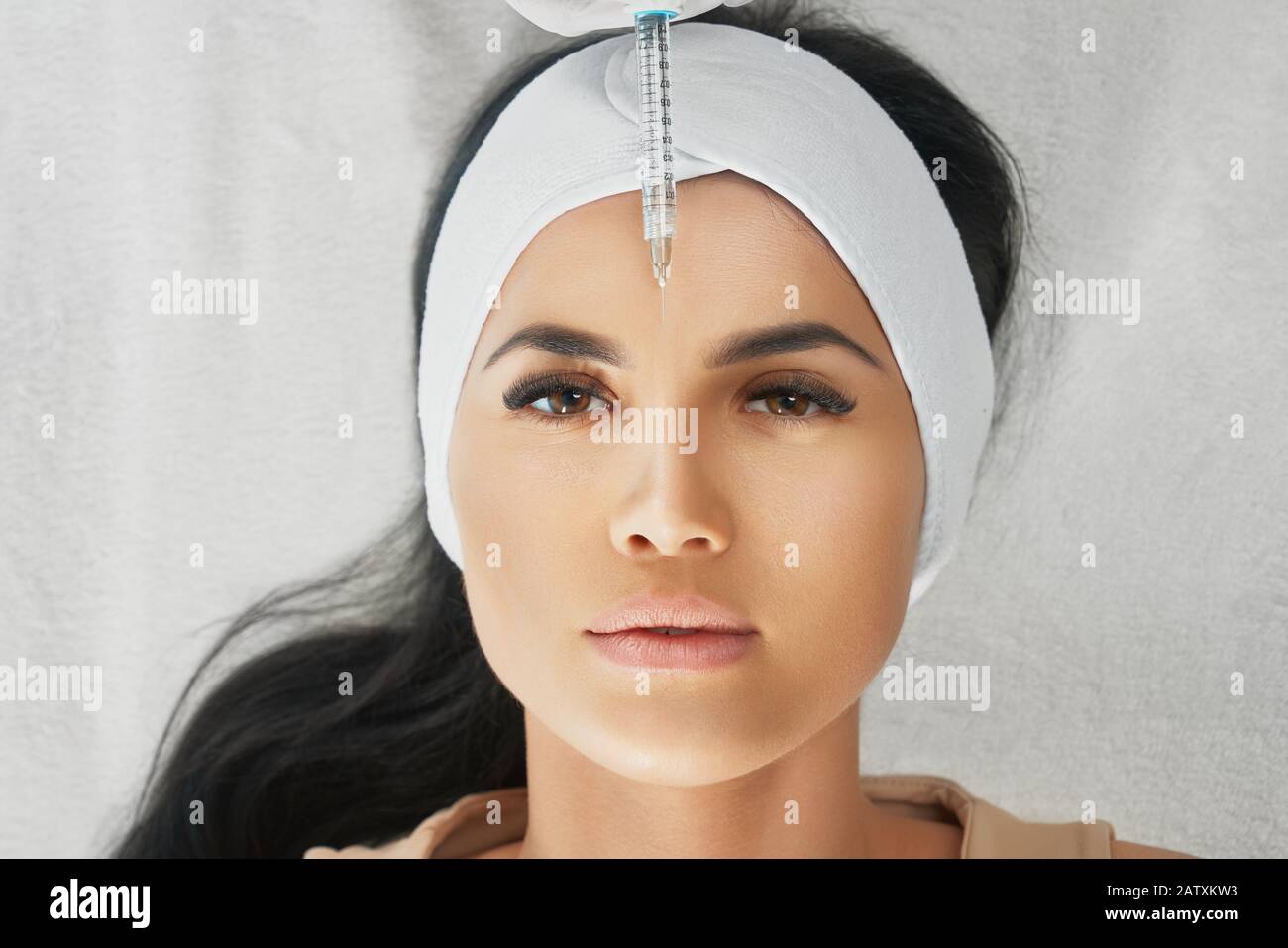 From above view of botox injection in female horehead. Cosmetologist ...